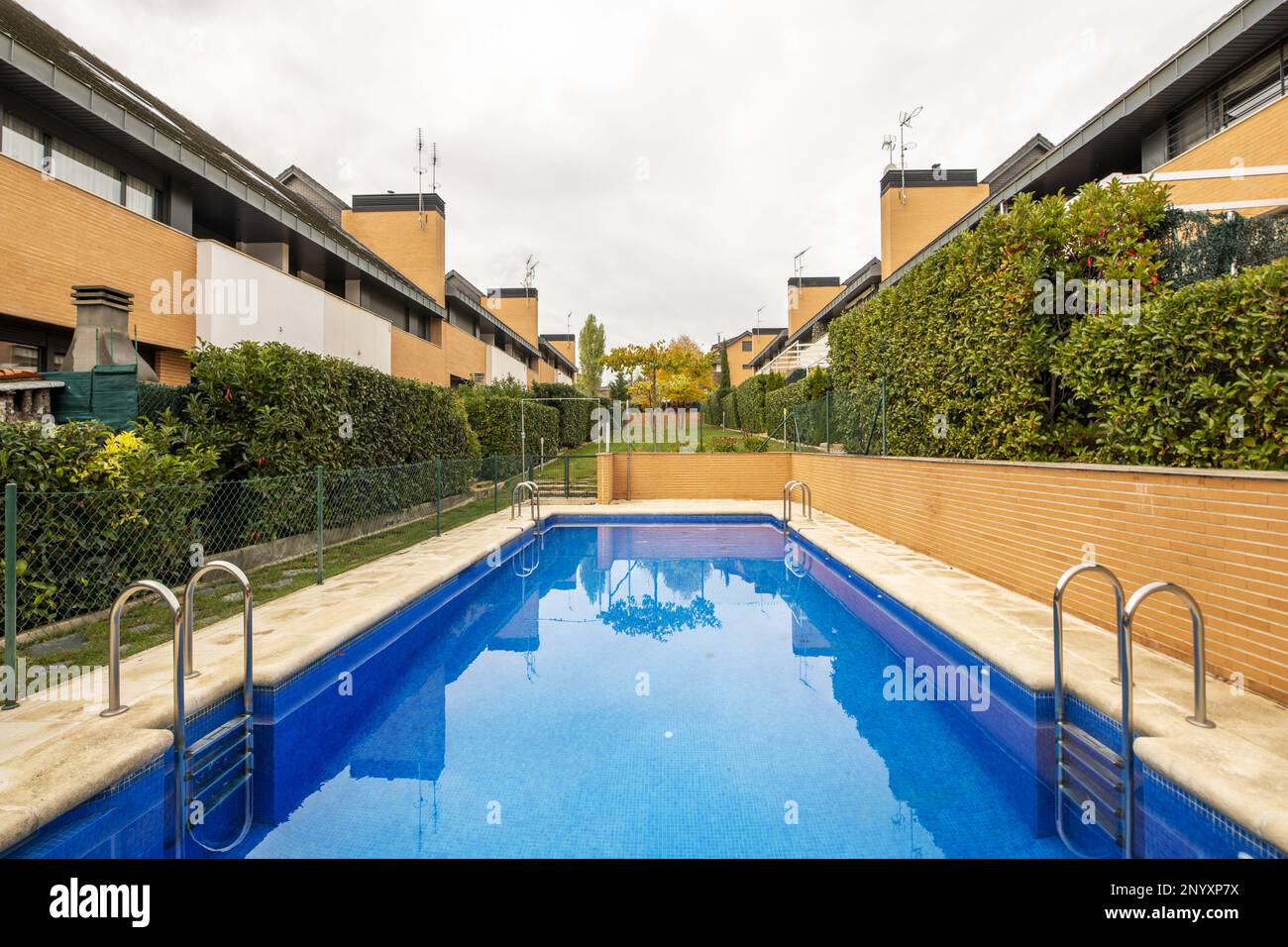 Community summer pool in the middle of a corridor between walled single ...