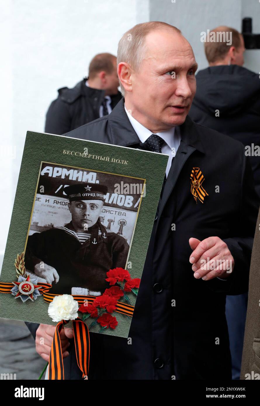 Russian President Vladimir Putin holds a photograph of his father in a ...