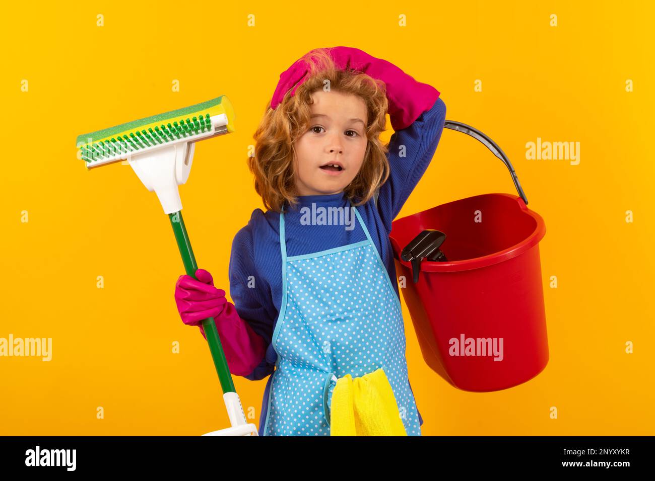 Studio portrait of child helping with housework, cleaning the house ...
