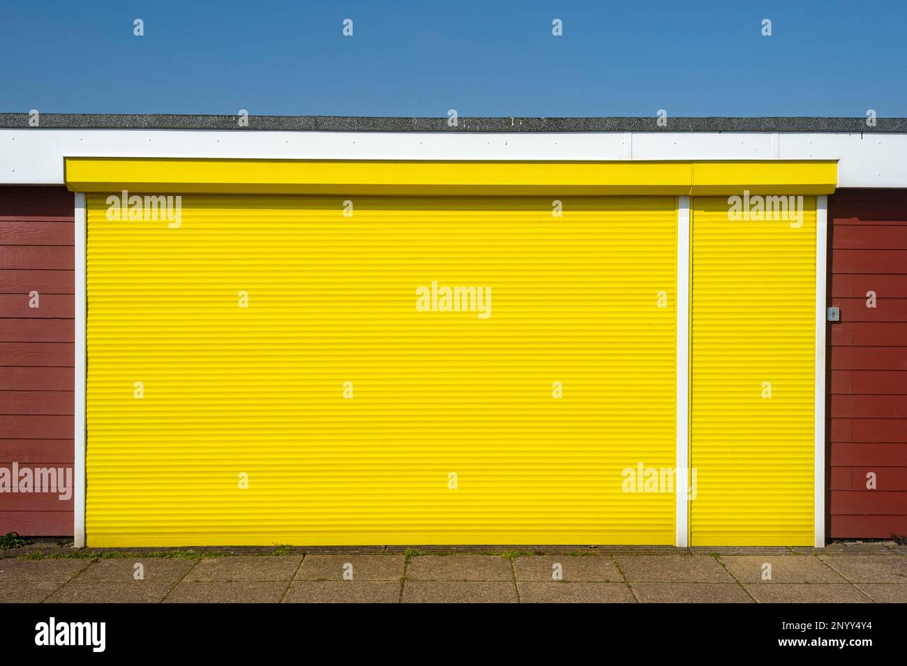 Building with closed yellow roller shutters Stock Photo - Alamy