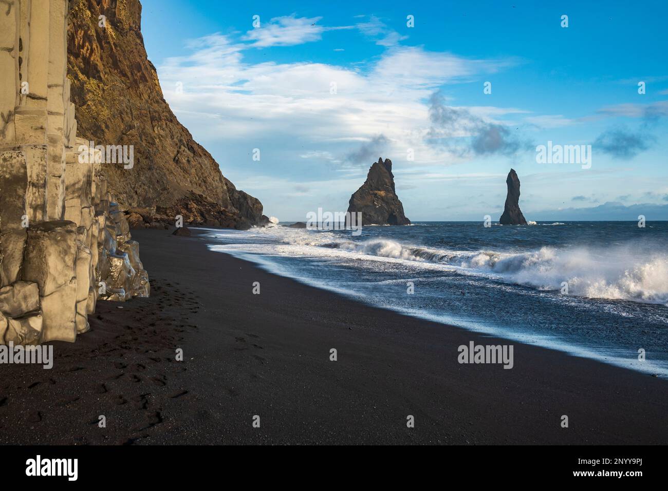 Scenic view of the black lava beach of Reynisfjara, Iceland, with the famous basalt columns of ...