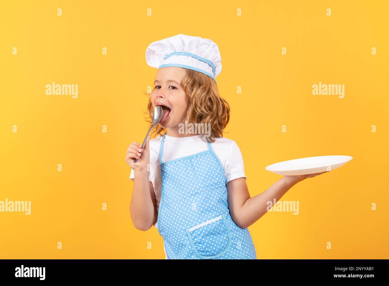 Funny kid chef cook with kitchen plate and spoon, studio portrait ...
