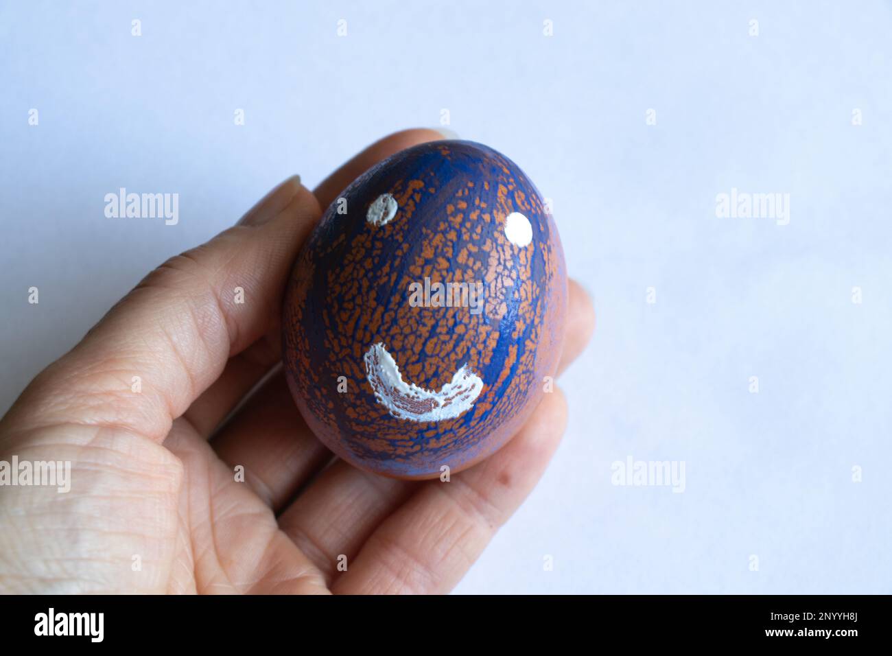 on the egg is drawn a smiley lies in the female palm Stock Photo - Alamy