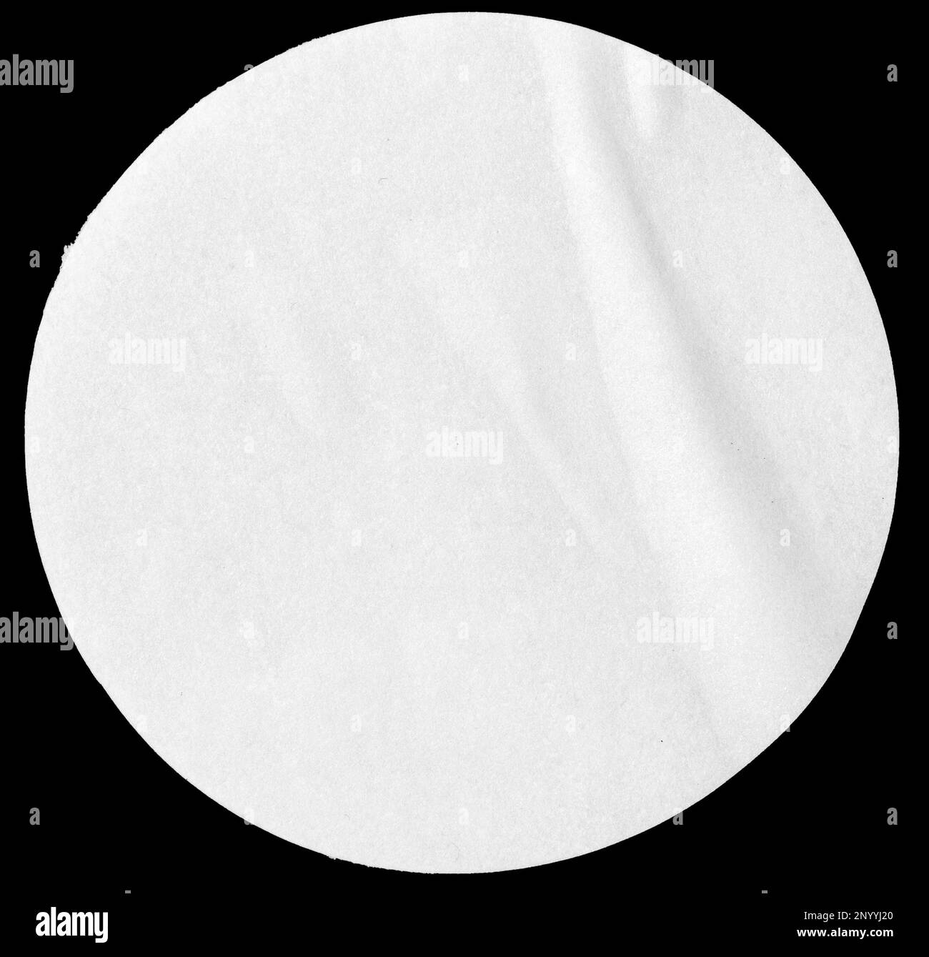 Blank white circle shape label isolated on black background. Crumpled ...