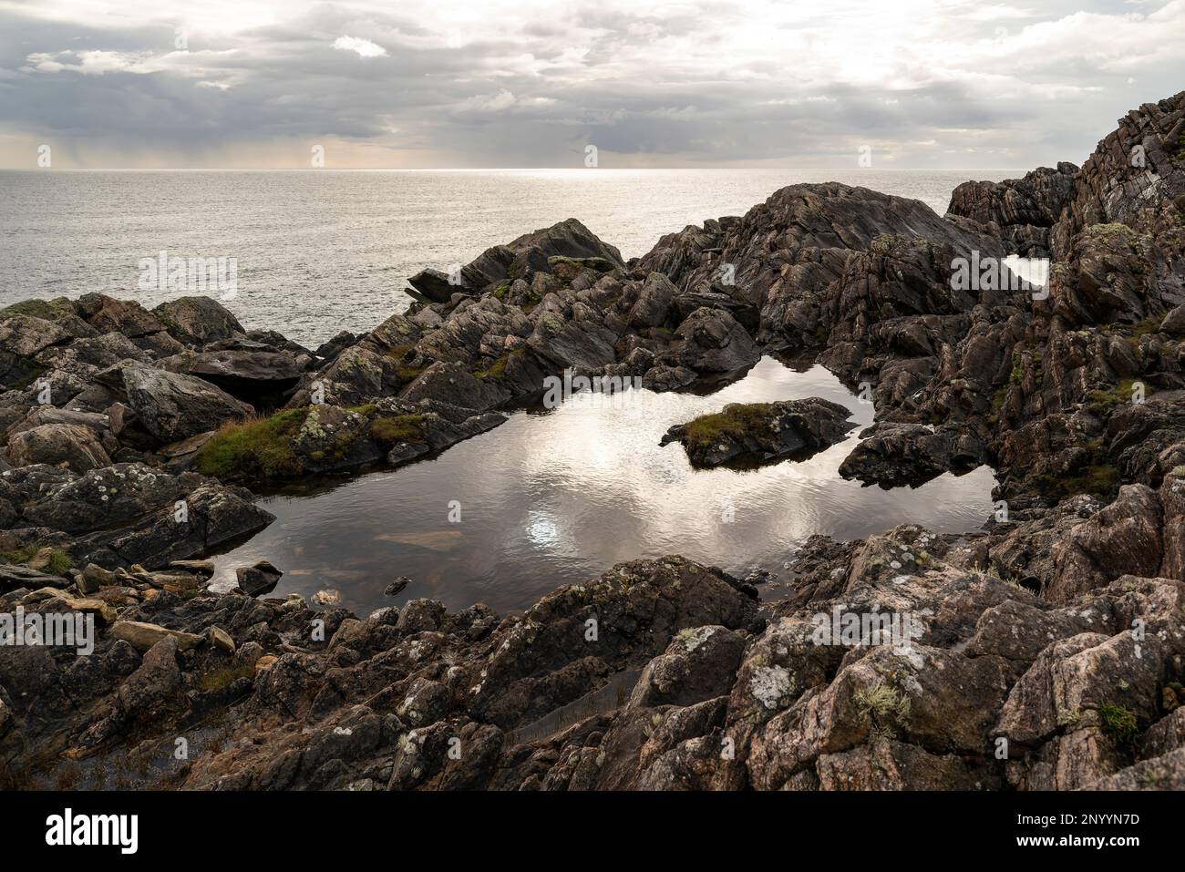 Dramatic sky reflected in a rock pool at Annagh Head, Mullet peninsula ...