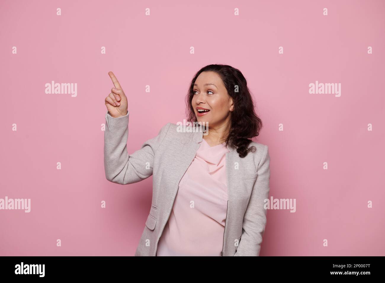 Pretty woman in light gray formal suit, pointing index finger at a copy ...