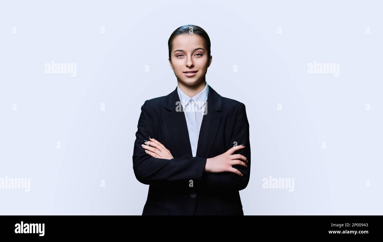 Teenage female student in black suit looking at camera on white ...