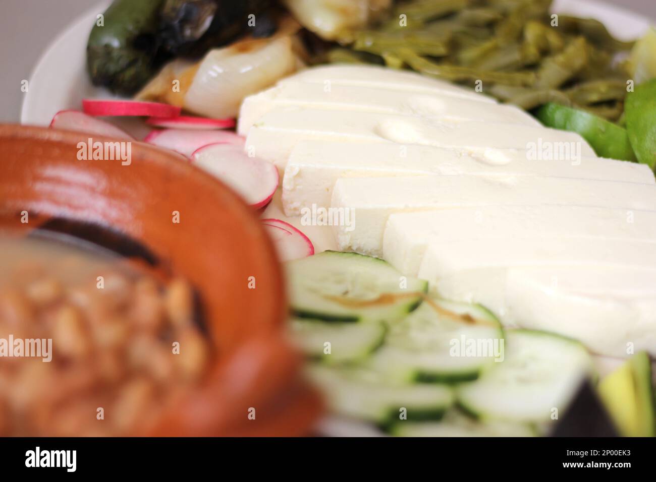 Plate of typical Mexican snack with cheese, nopales, chili peppers ...