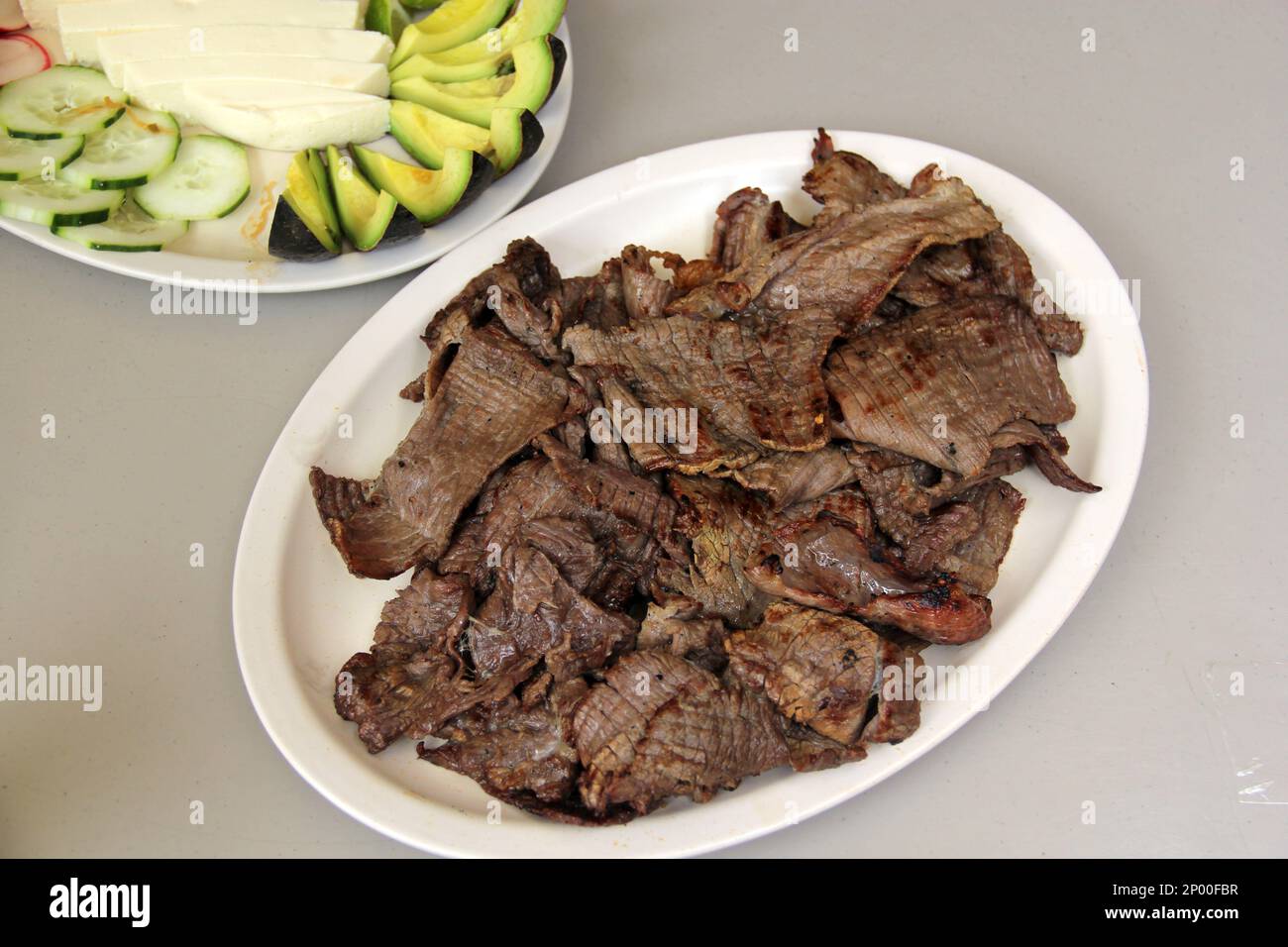 Typical Mexican food, roast beef and sausage with cheese, nopales ...