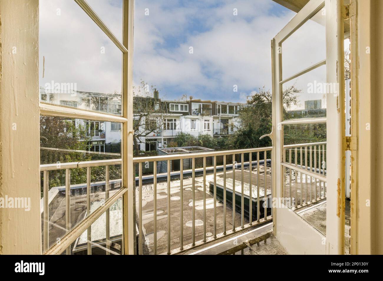 an open window looking out onto the street and houses in the distance ...
