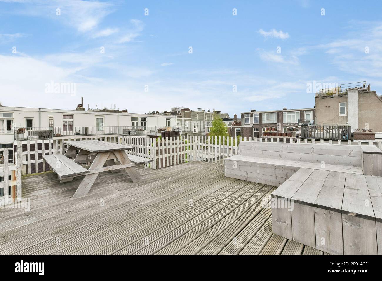 a rooftop with picnic tables and benches on the wooden deck in front of ...