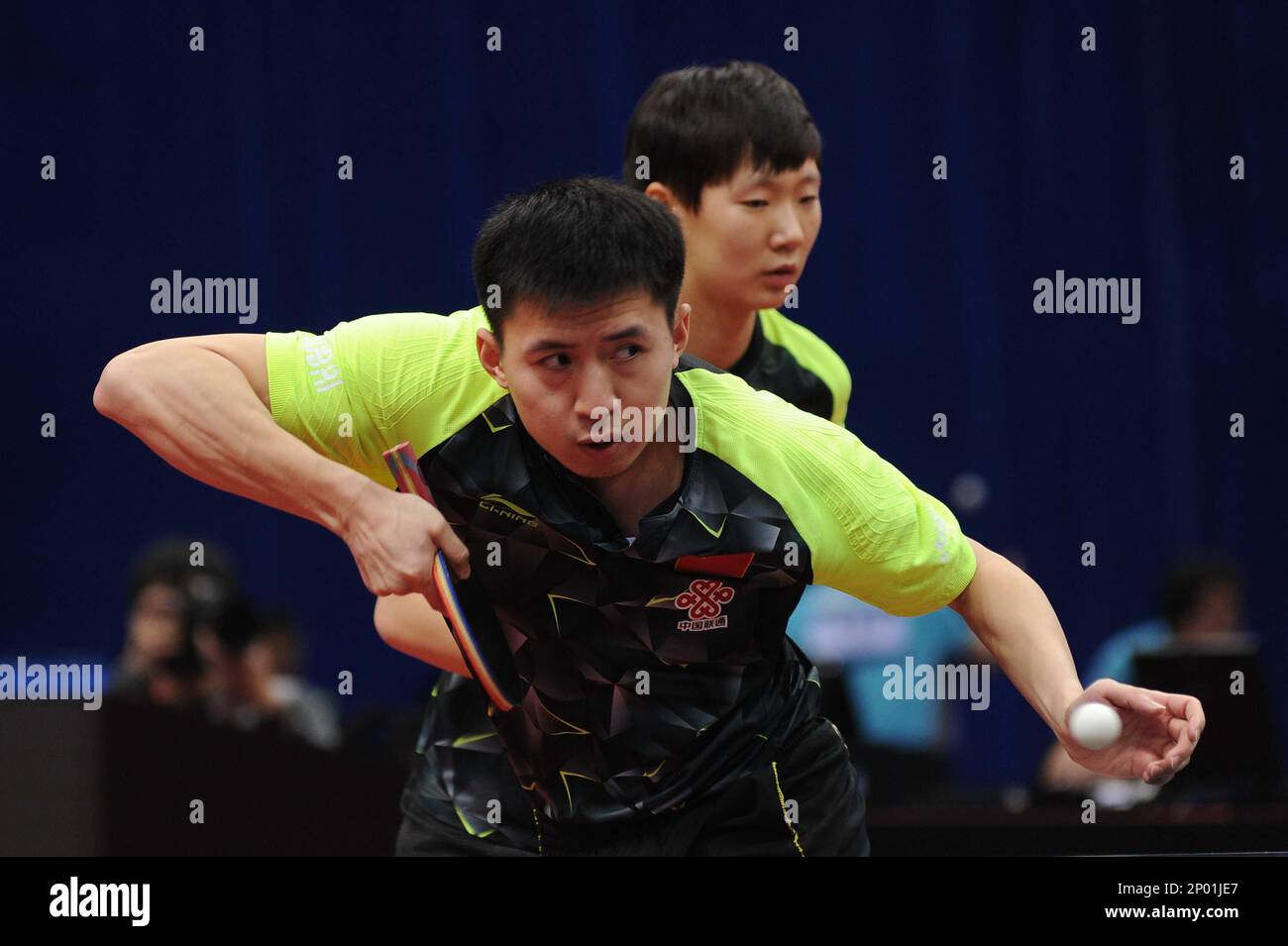 Fang Bo, front, serves as he and Wang Manyu of China compete against ...