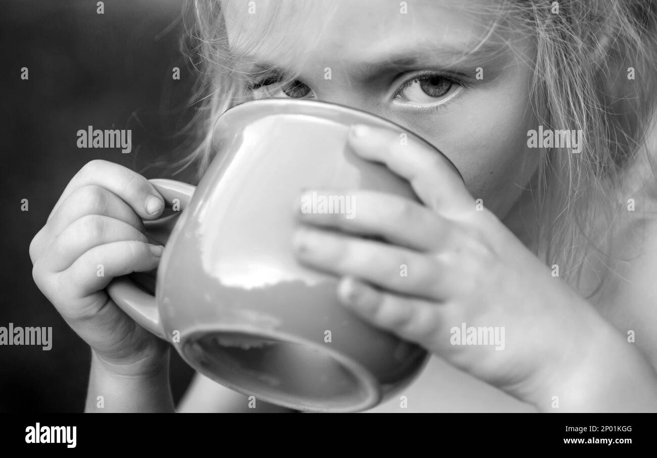 Girl drinking something. Water. Juice. Milk. Happy child in summer in ...