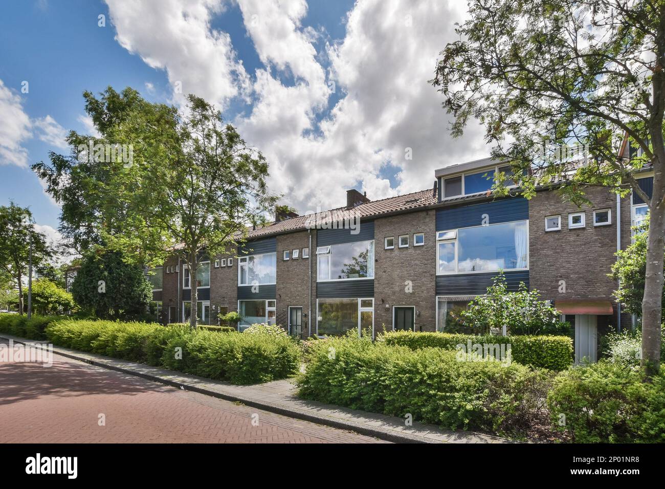 an apartment complex in the netherlands, with trees and bushes on ...