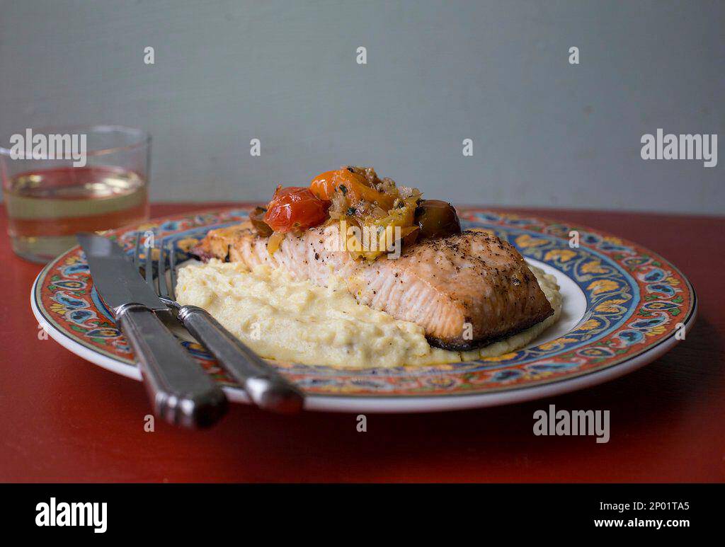 This February 2017 photo shows salmon with polenta and warm tomato ...