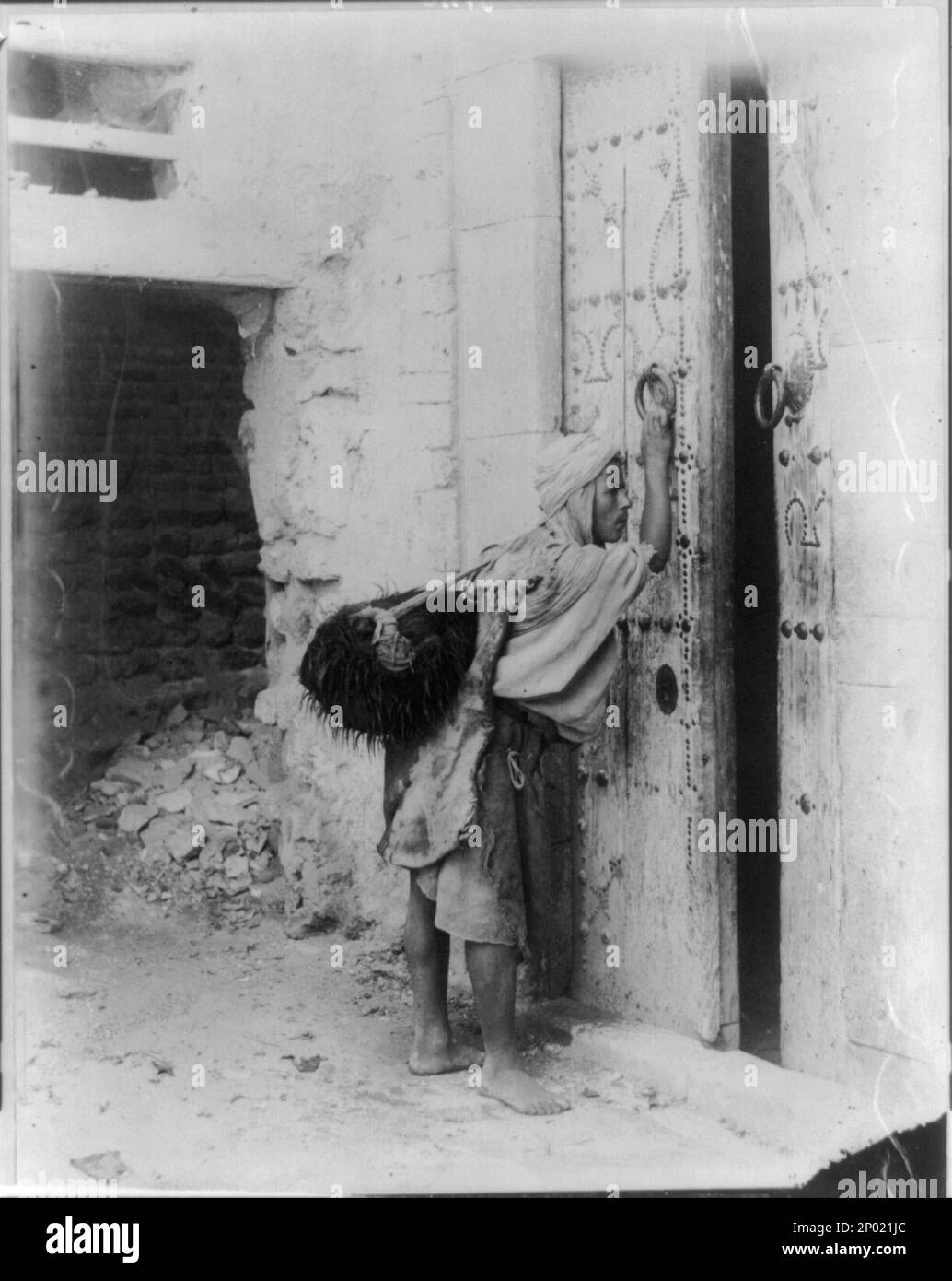 Porter at Tunis opening large door. ca. 190-. Tunisia, Frank and ...