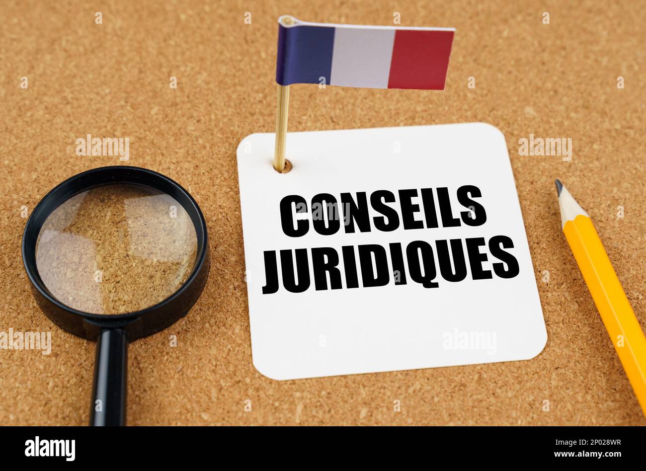 On the table is the flag of France, a pencil, a magnifying glass and a ...