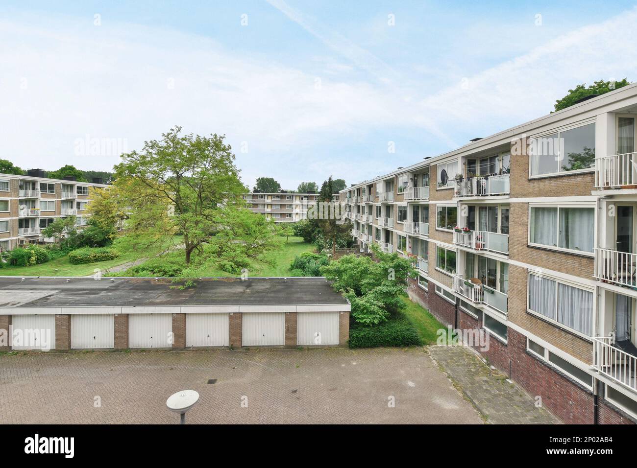 an apartment complex with trees in the yard and buildings on either ...