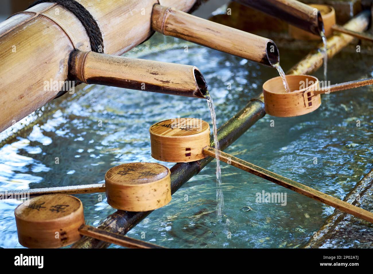 Water flowing from a Chōzubachi (water vessel) in water ladles at ...