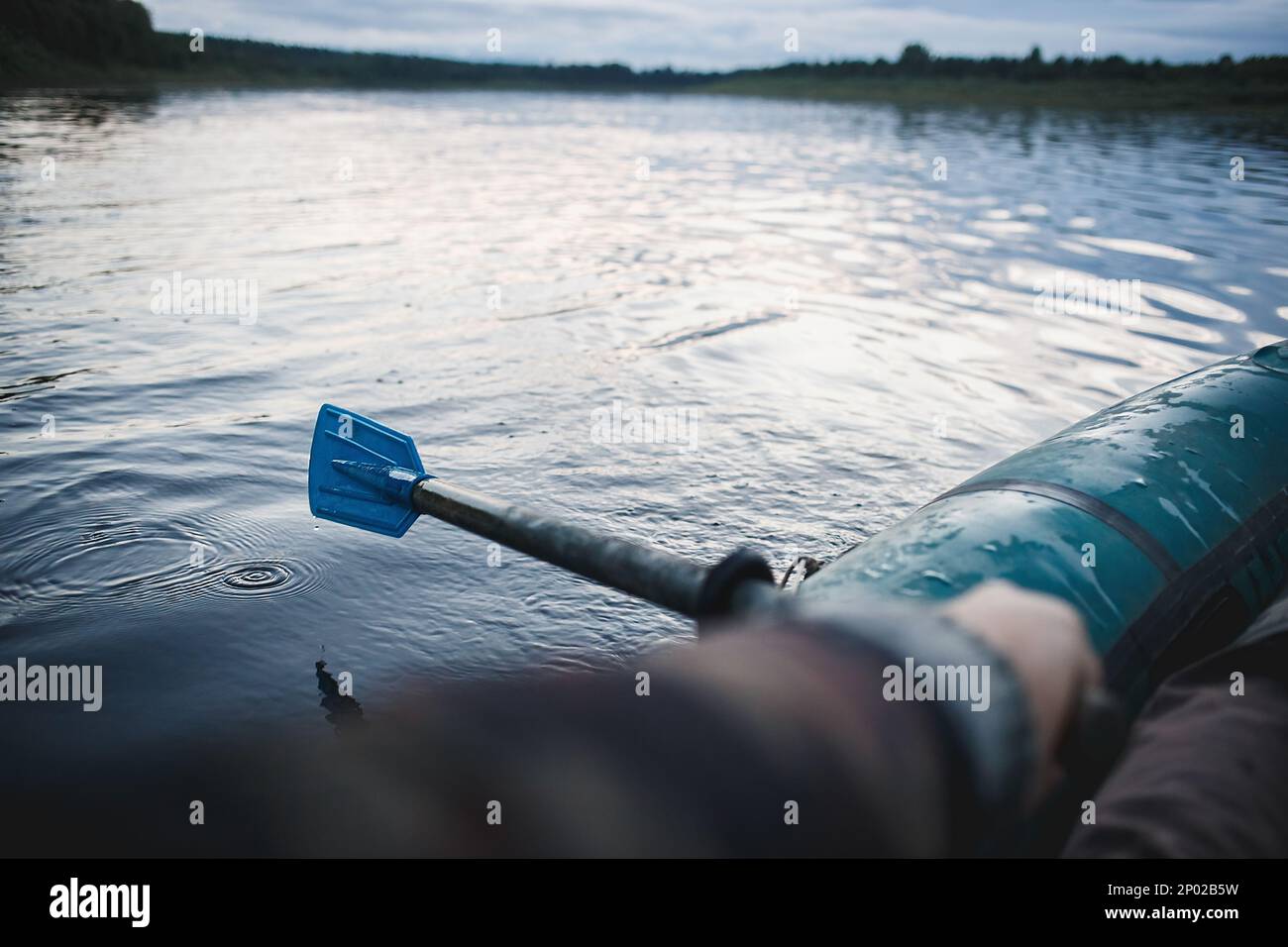 The paddle of a rubber boat while rowing on the river after sunset ...