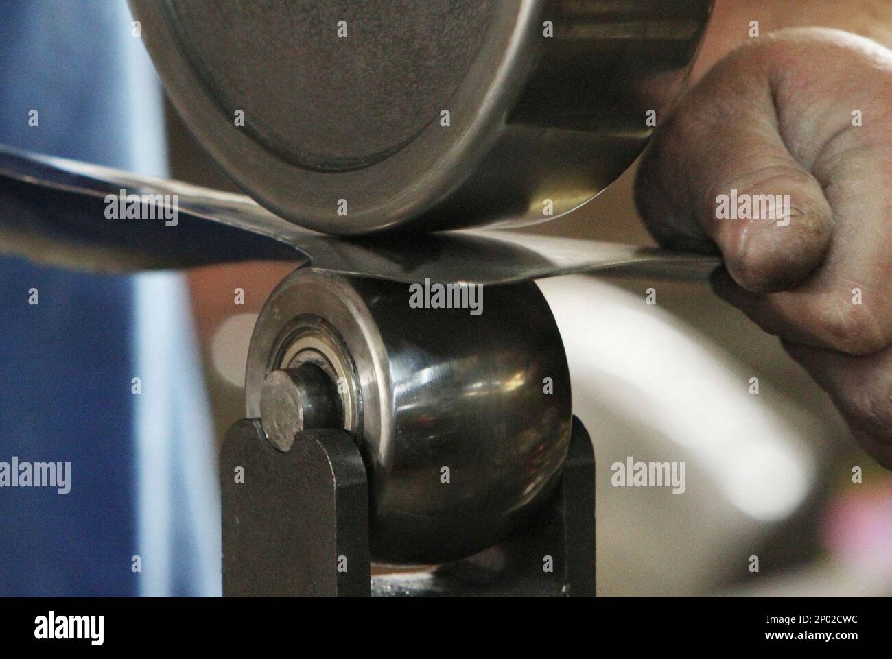 Chad Grayek, Overton, uses an English wheel to form a curve in a piece ...