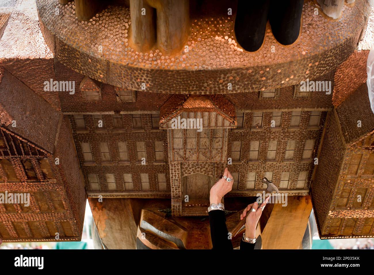 A woman hammers a copper nail into the Reconciliation Pole before its ...
