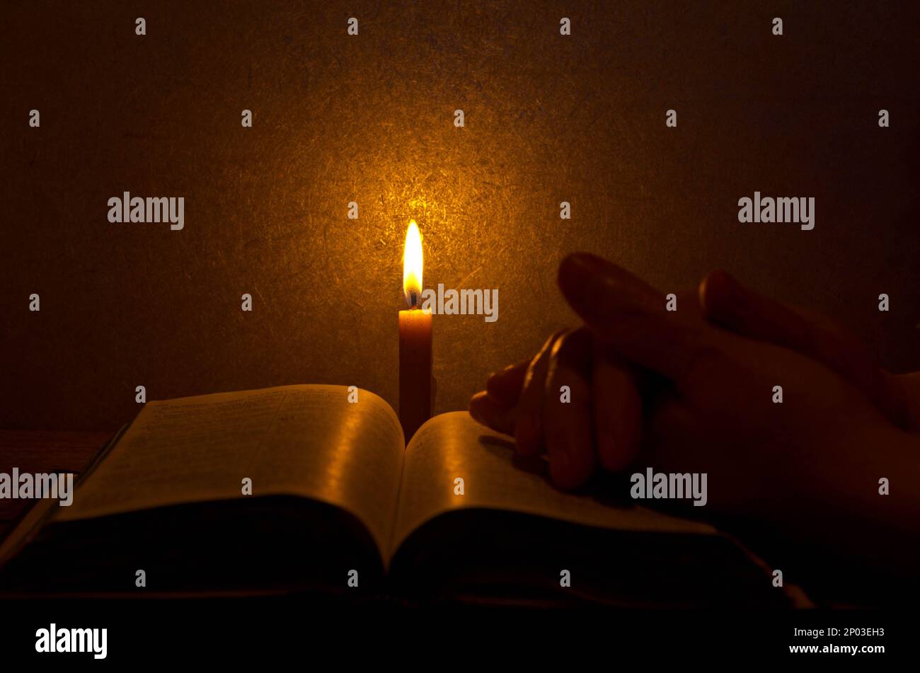 Burning candle on an open book in dark room with copy space. reading a ...