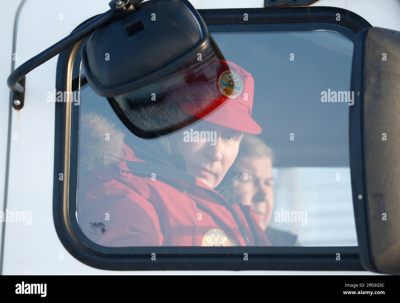 Russian President Vladimir Putin looks through a bus window while ...