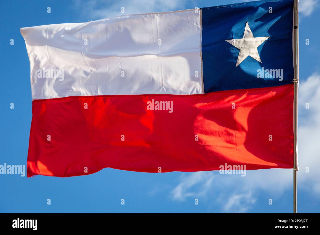Chile National Flag Waving on pole against sunny blue sky background ...