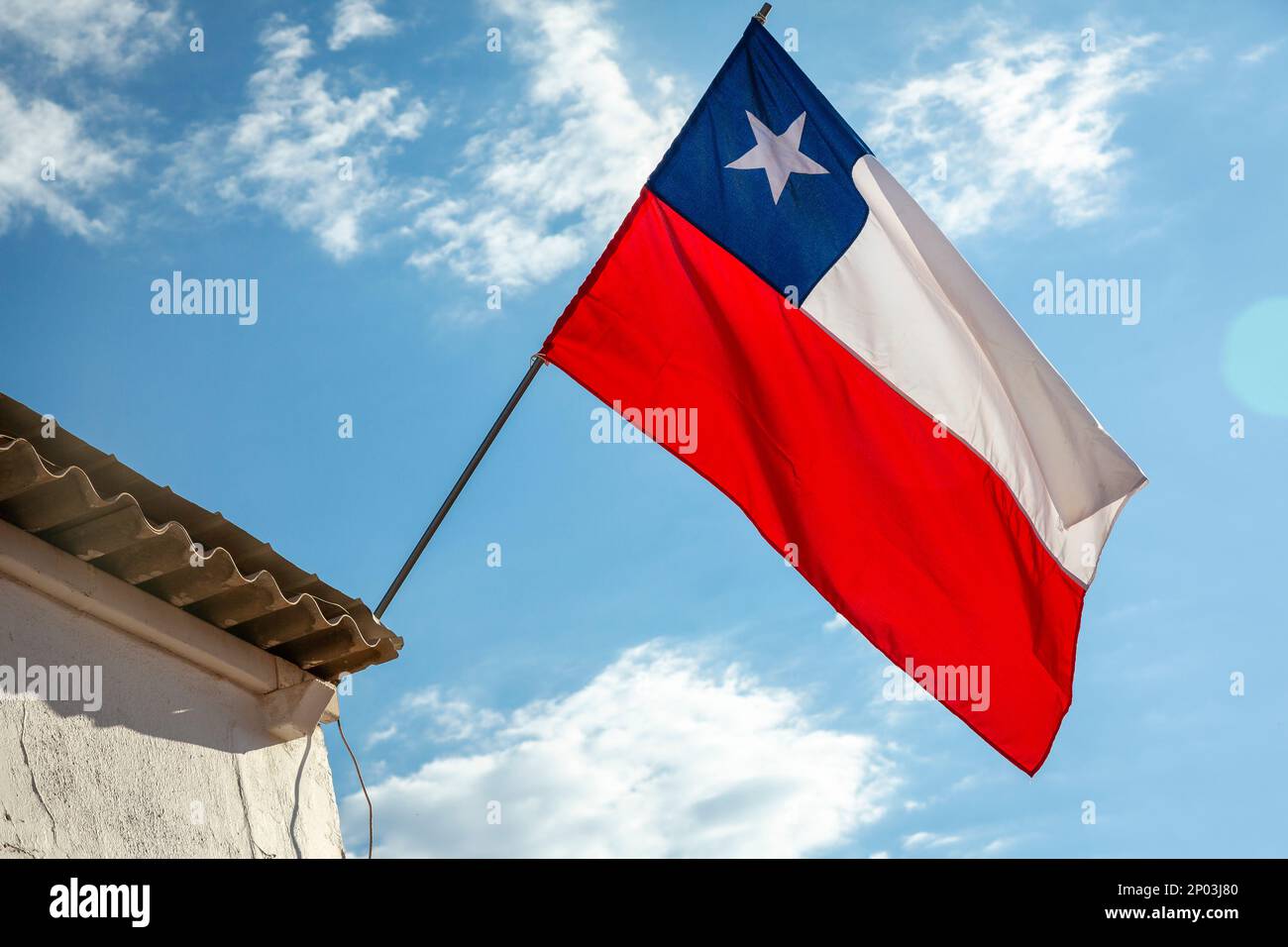 Chile National Flag Waving on pole against sunny blue sky background ...