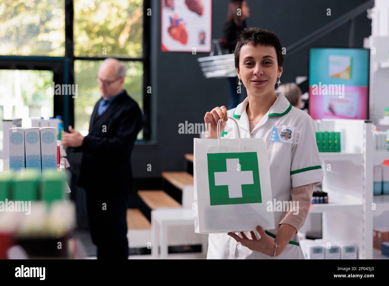 Pharmaceutical employee holding medical retail store shopping bag ...