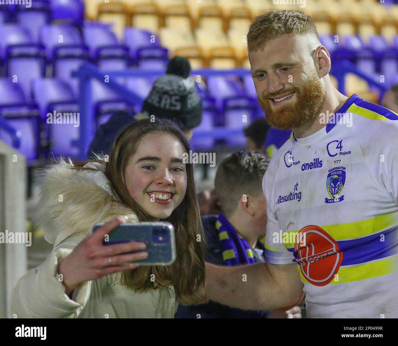 Joe Bullock #19 of Warrington Wolves takes a photo with a young fan ...