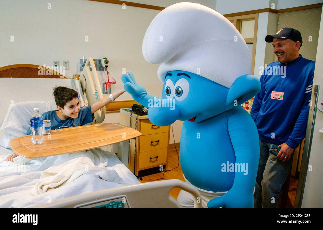 A performer dressed as Hefty Smurf gives a high-five to Jack Gall, 13 ...