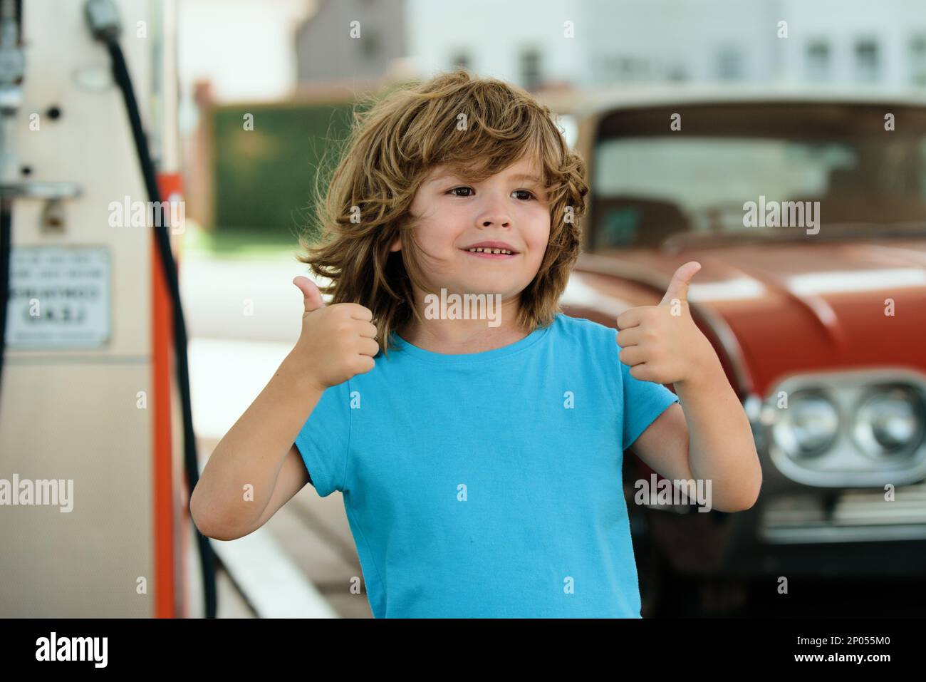 Kid refuel the car. Gas station. Red retro automobile Stock Photo - Alamy