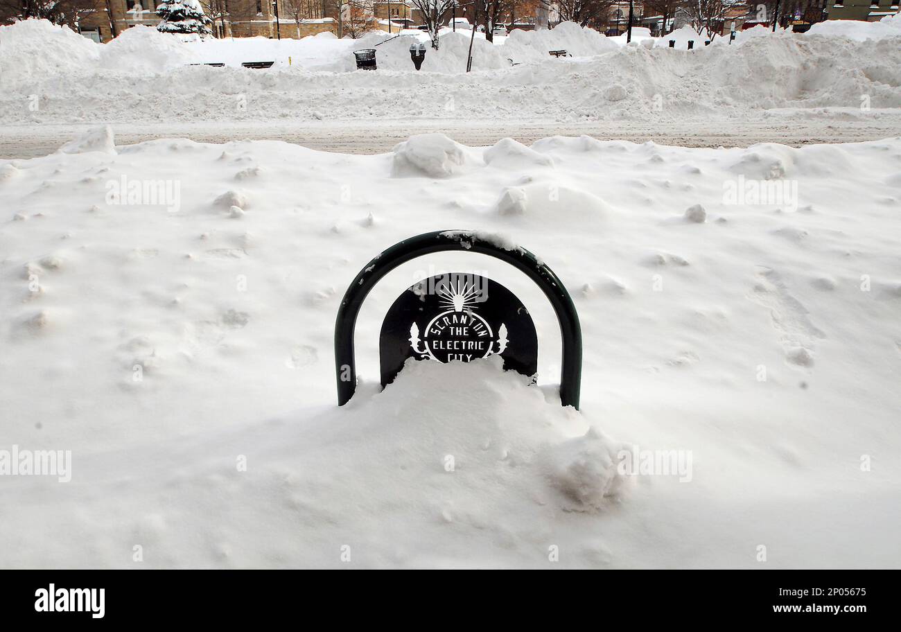 A bicycle rack is submerged in several feet of snow in downtown ...