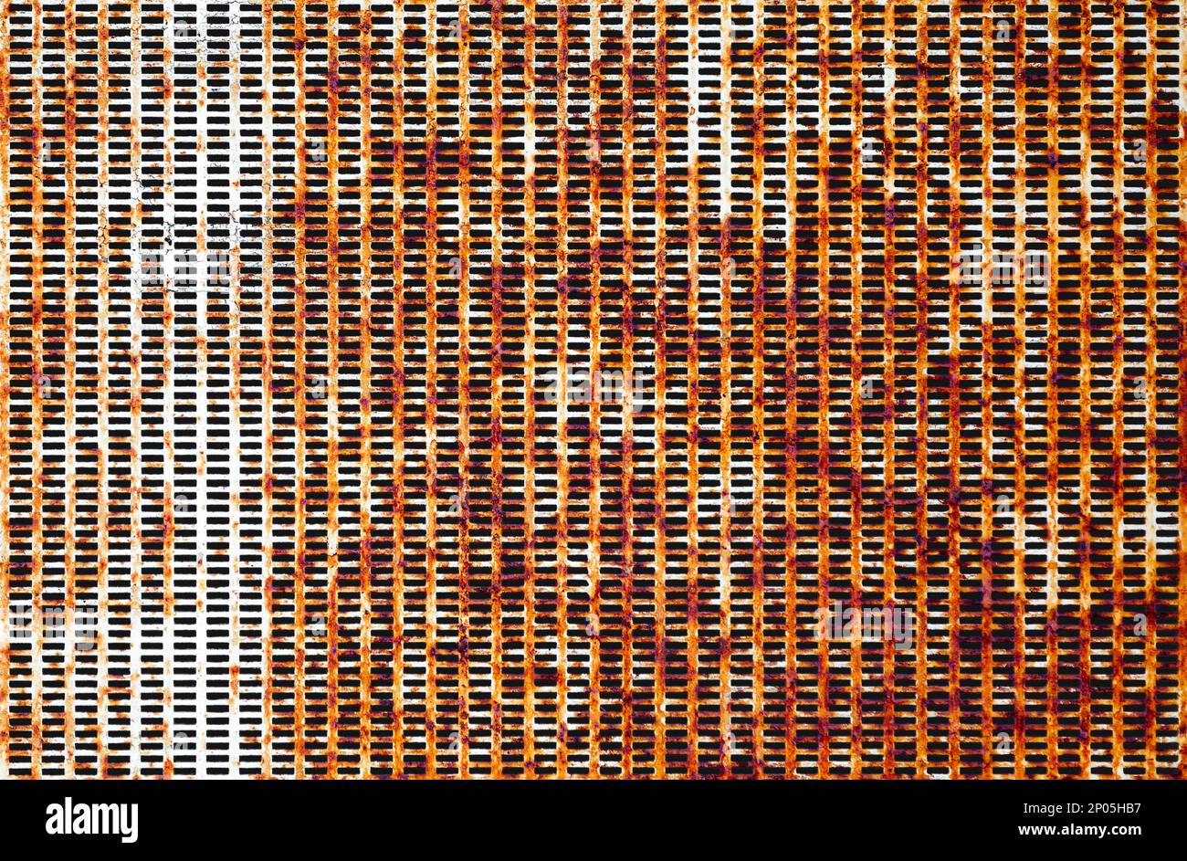 Full frame close-up on a rusty metal plate with rectangular holes all ...