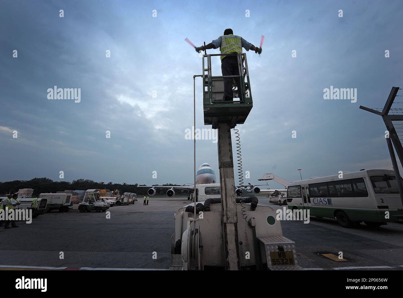 A marshaller signals a cargo plane to move into position at the Cargo ...