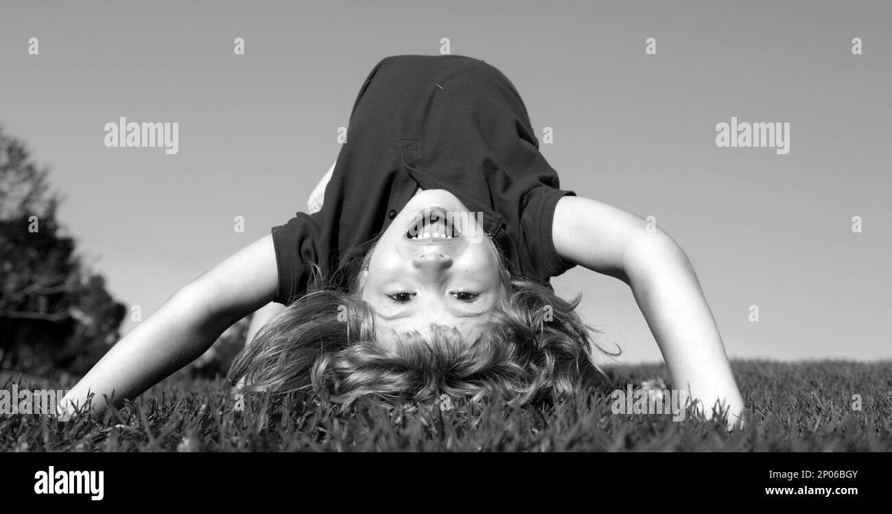 Banner with spring kids portrait. Happy child playing upside down on ...