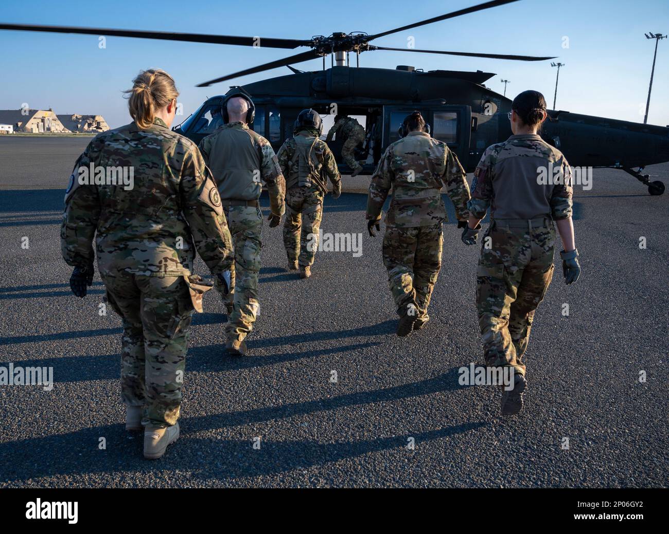 A group of U.S. Air Force Airmen approach a UH-60 Blackhawk helicopter ...