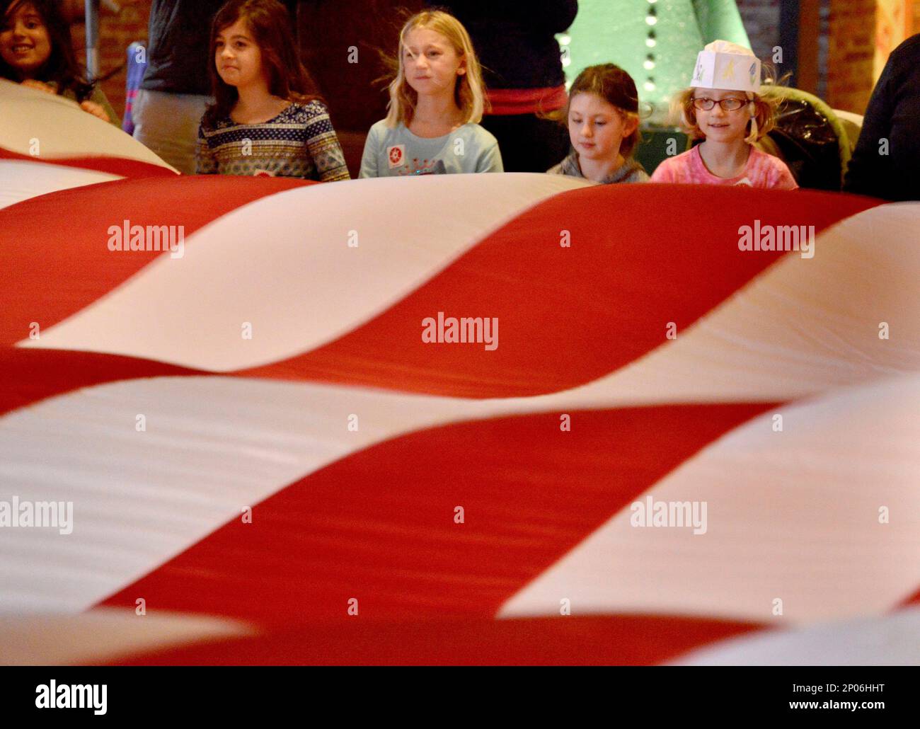 Children and parents wave the 36 foot long American Flag in the Sen ...