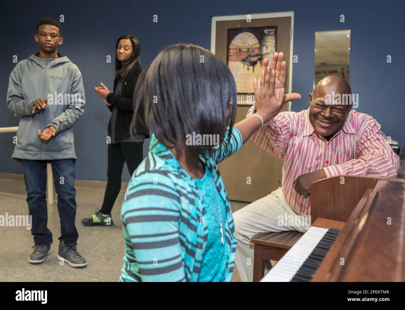 Piano instructor Duncan Butler high-fives Jaslyn Sims after she played ...