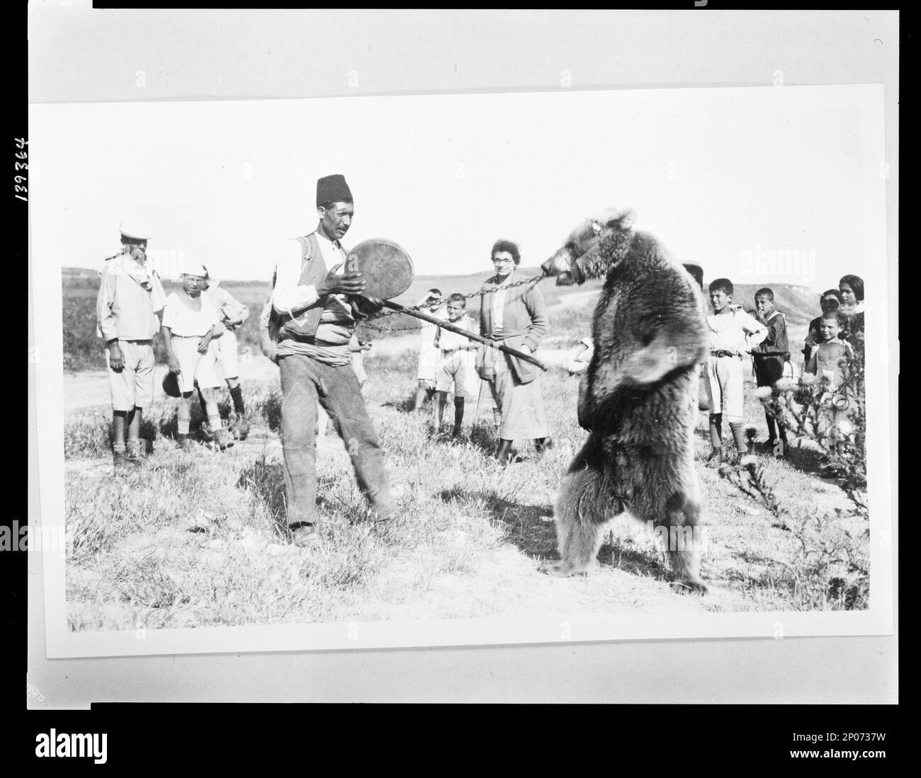 Dancing bear and trainer perform as children watch at Floria Beach, Istanbul, Turkey. Title ...