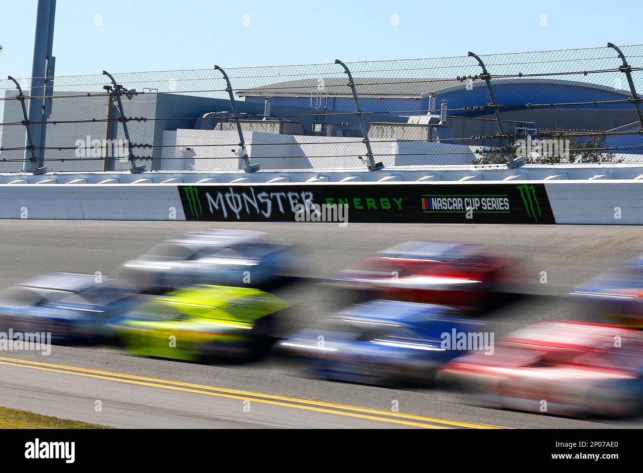 The field streaks by the Monster Energy signage during the NASCAR ...