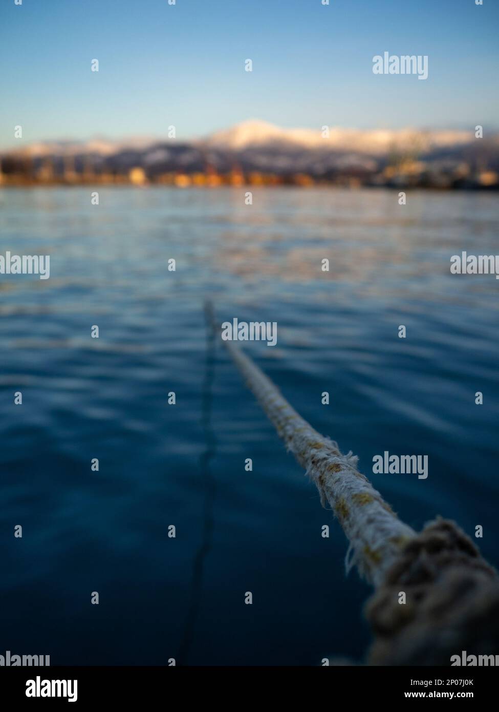 rope goes into the water from the bollard. Attaching boats to the pier ...