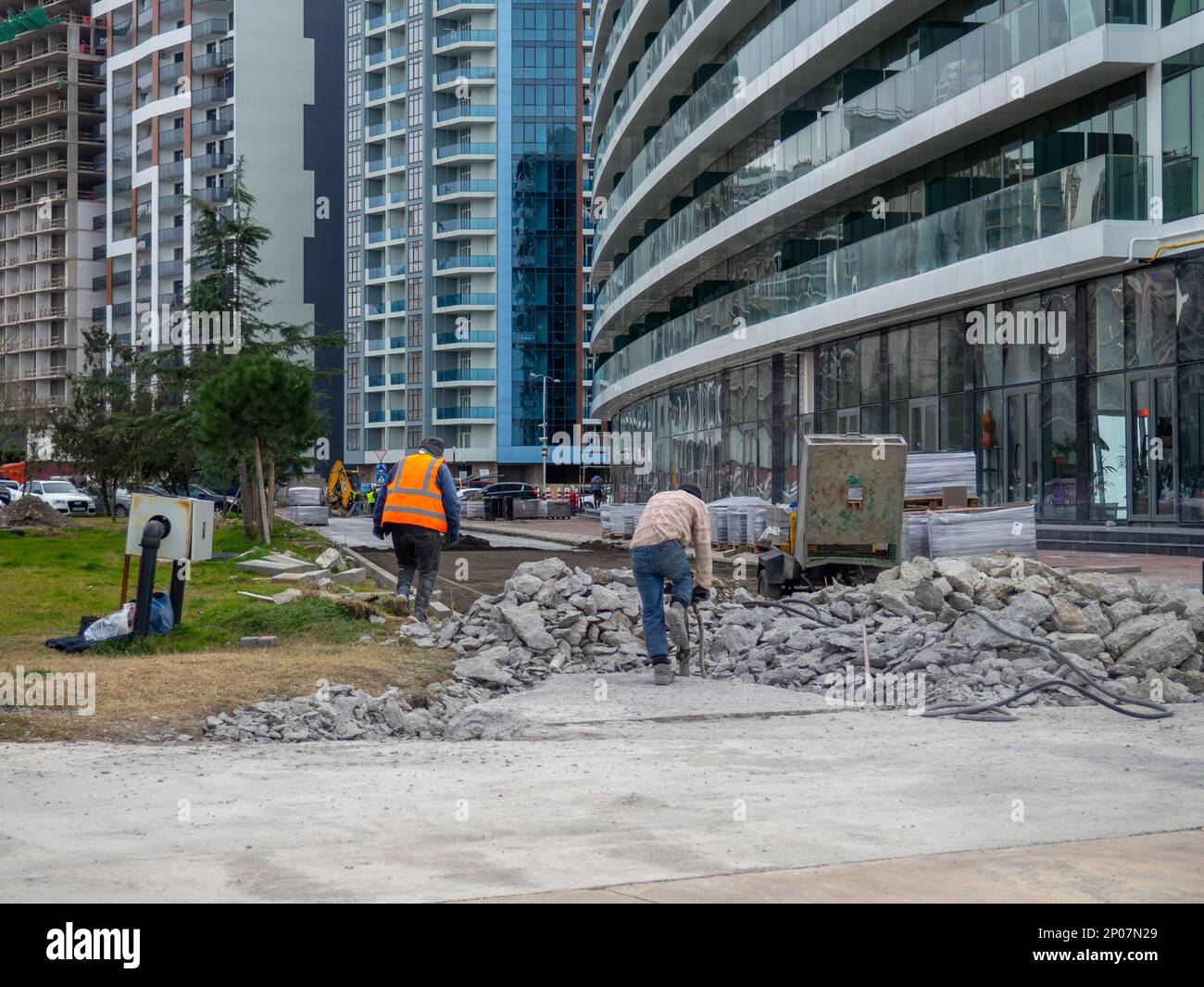 Workers break off concrete. Hard work. People are reconstructing the ...