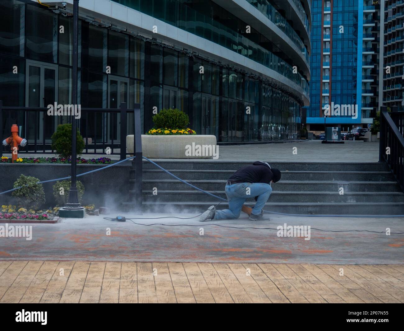workers are working. Hard work. A man polishes steps with a grinder ...