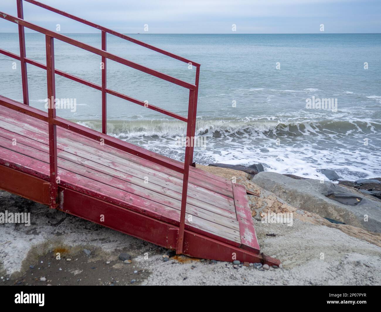 Wooden slope on the background of the sea. Wooden red riser. Ladder on ...
