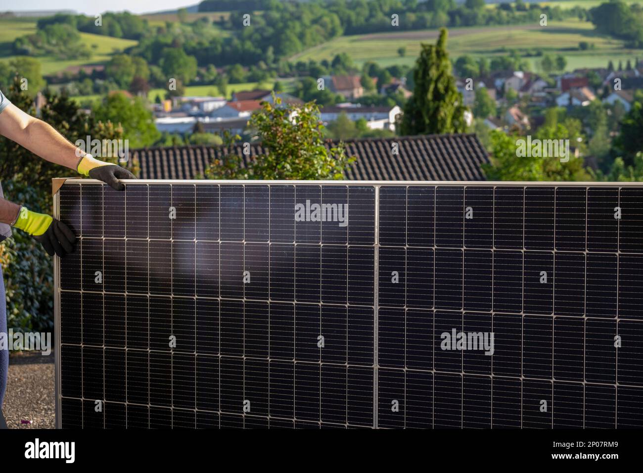 Solar energy. Solar panel in the hands of a worker on city houses ...
