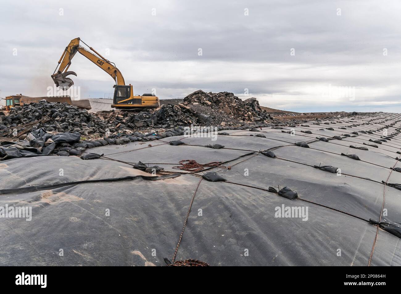 A power shovel loads debris onto a a dump truck at the top of a ...