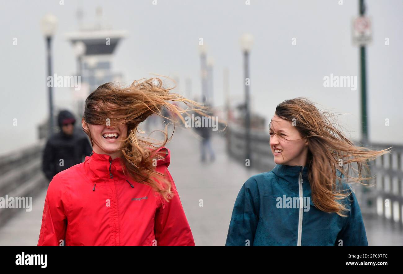 Emily Tate, left, and her sister, Catherine Tate, walk through strong ...